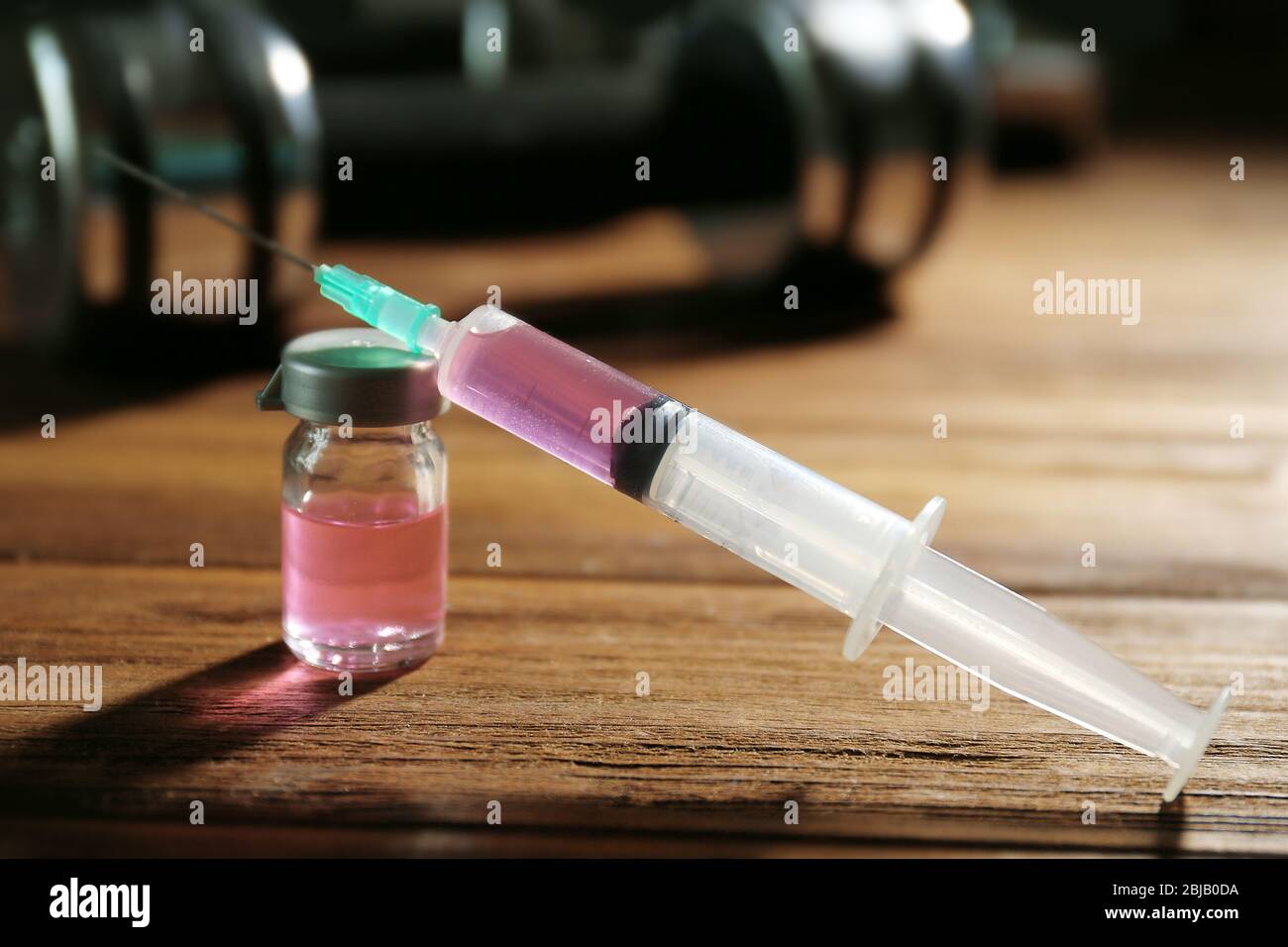 Syringe and dumbbells. Doping in sport concept Stock Photo - Alamy