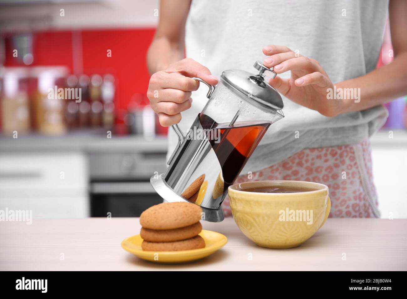 Woman giving some tea in kitchen Stock Photo - Alamy