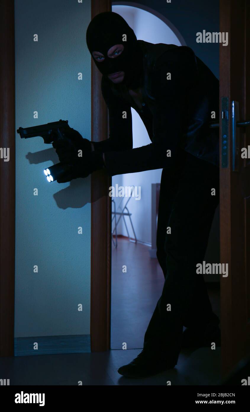 Armed thief entering a house Stock Photo - Alamy
