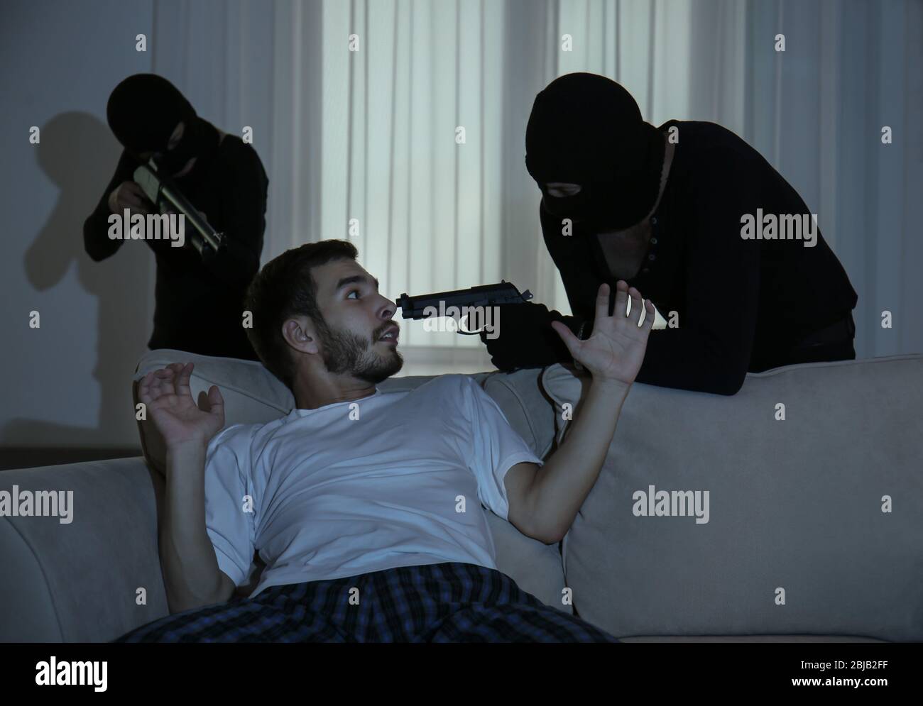 Armed thieves entering a house and threatening man Stock Photo - Alamy