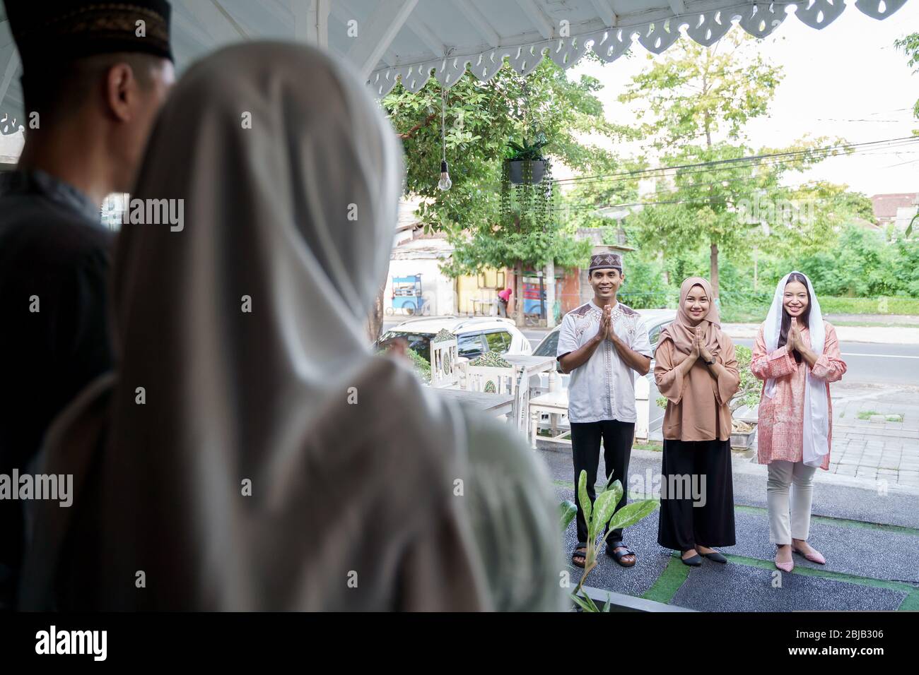 muslim family welcoming friend at home. visiting during eid mubarak ...