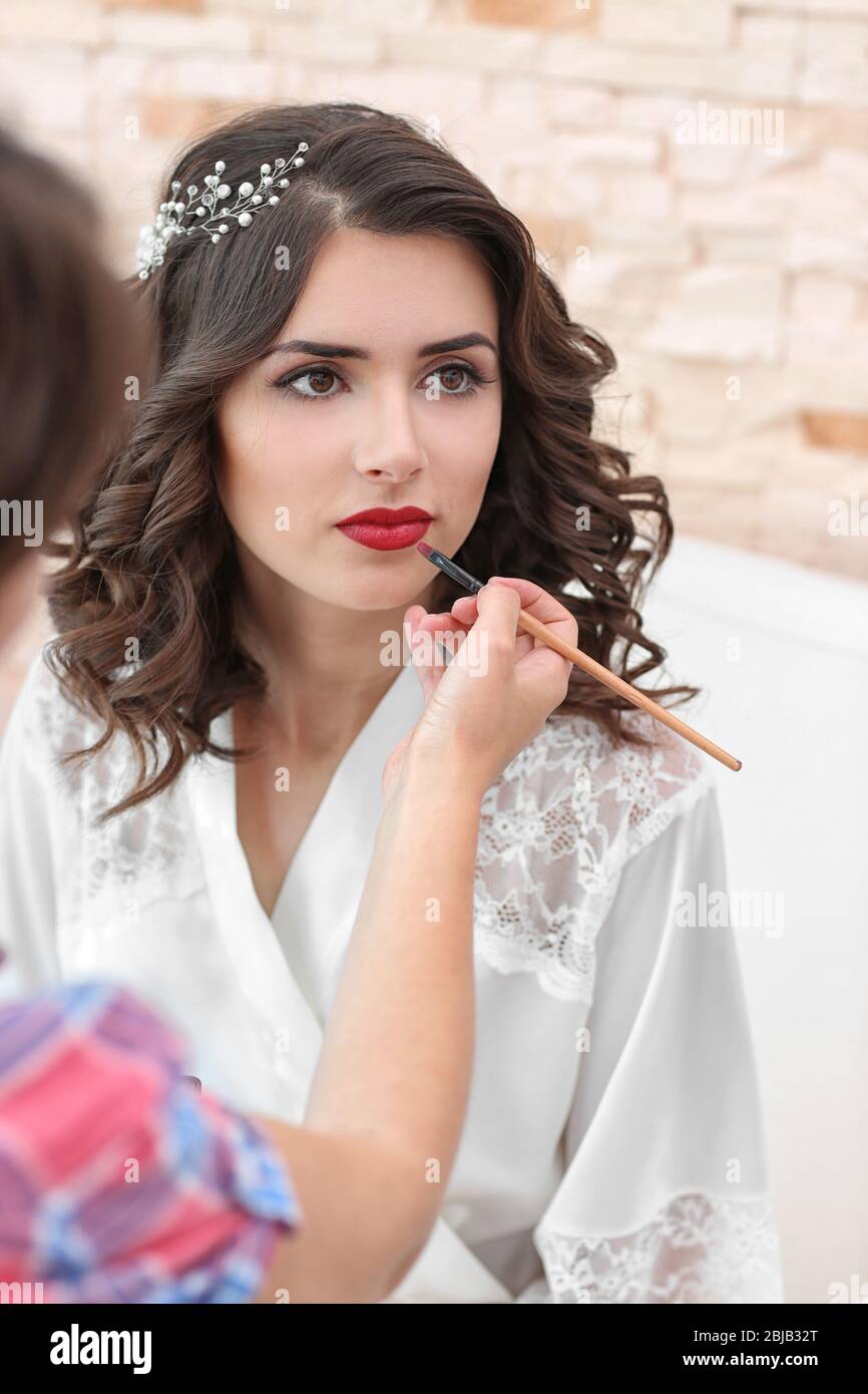 Makeup artist preparing bride before her wedding Stock Photo - Alamy
