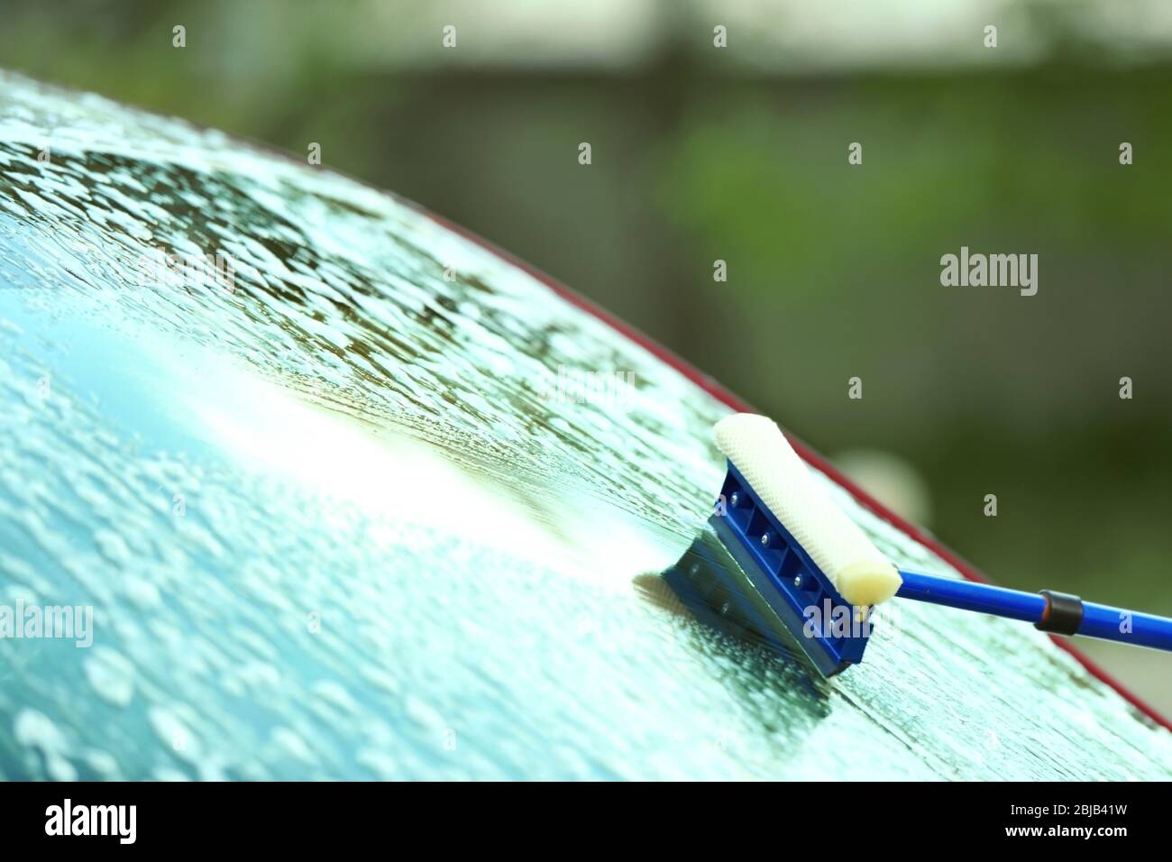 Washing windscreen with window cleaner Stock Photo - Alamy