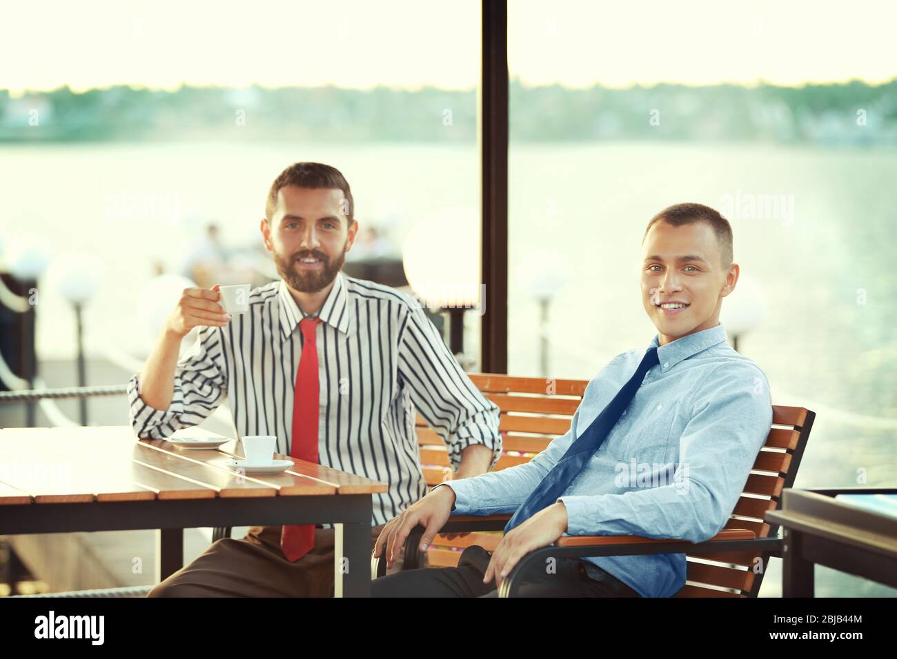 Men drinking coffee in cafe, outdoors Stock Photo - Alamy