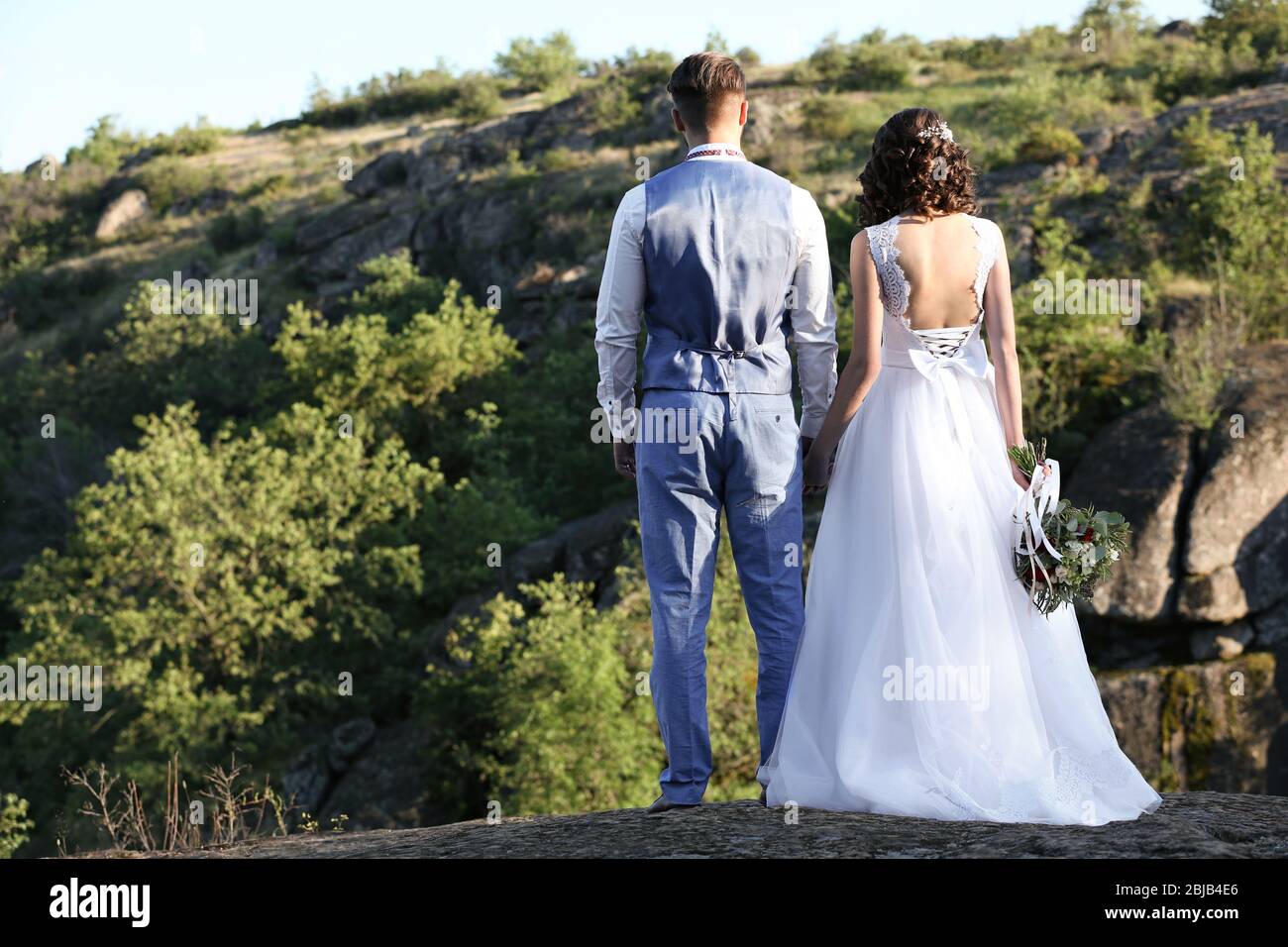 Bride and groom standing over beautiful landscape Stock Photo - Alamy