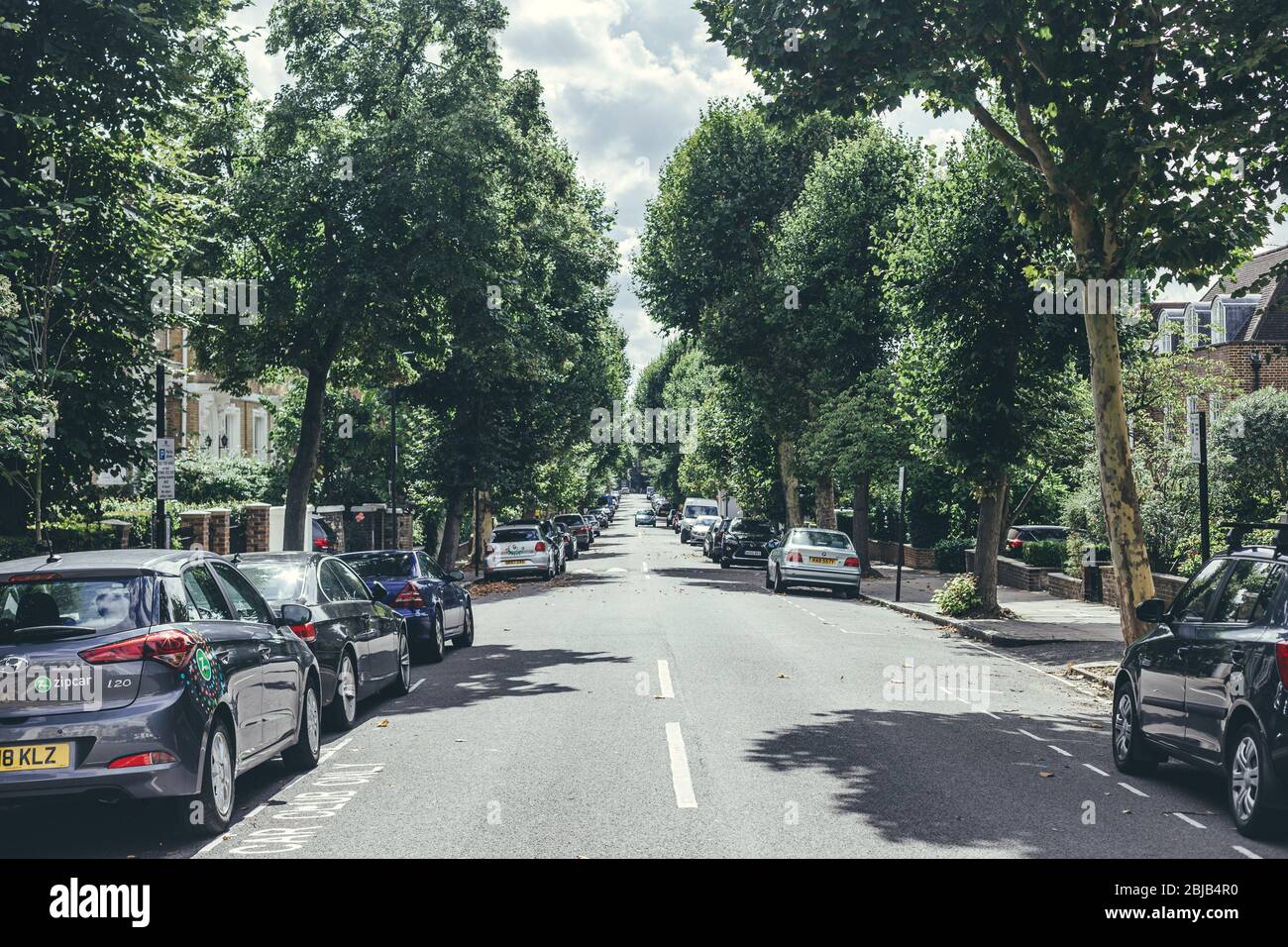 London/UK-30/7/18: Springfield Road with trees and parked cars on the ...