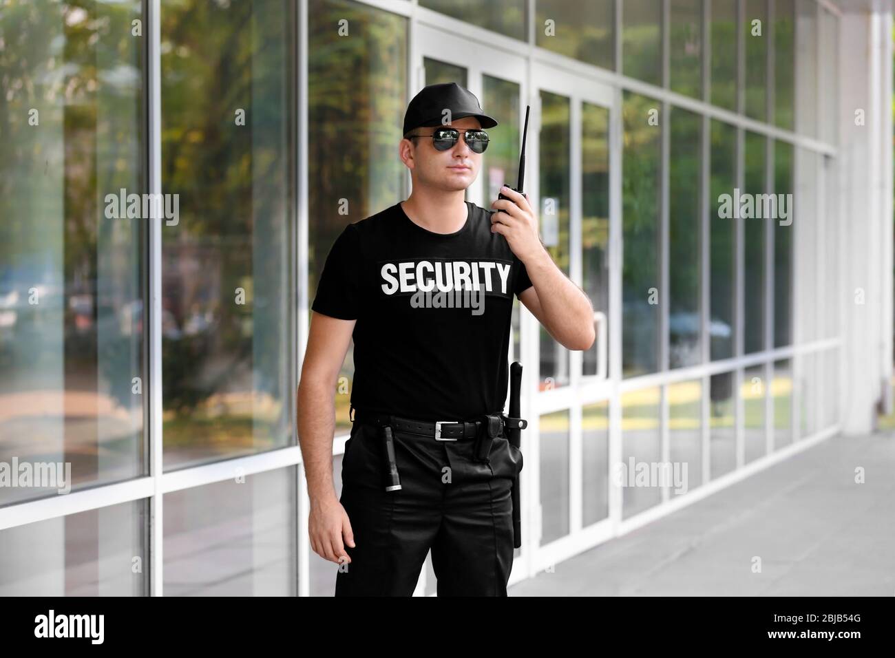 Male security guard with portable radio outdoors Stock Photo - Alamy