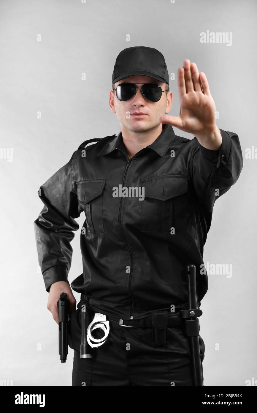 Male security guard on grey background Stock Photo - Alamy