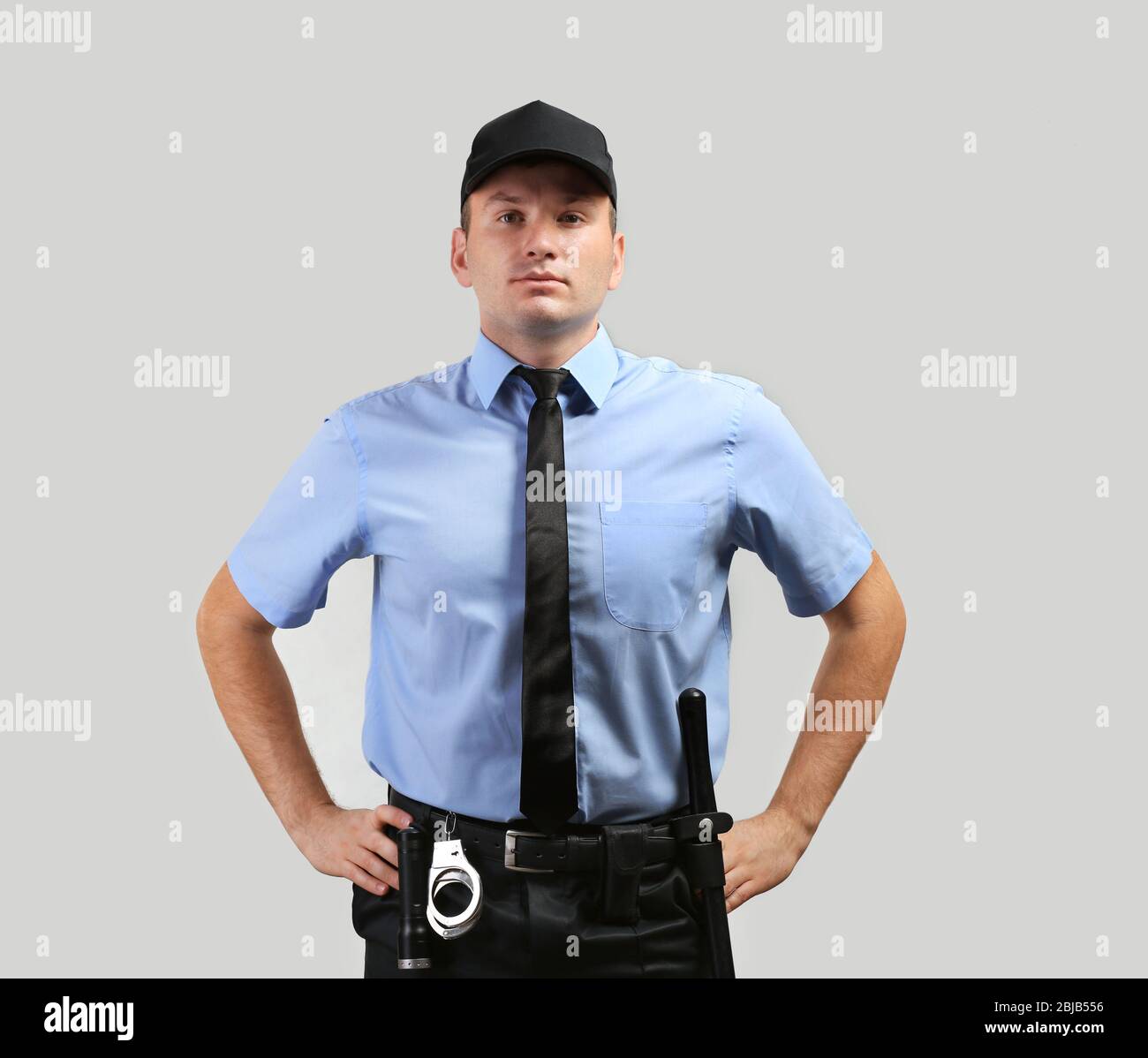 Male security guard on grey background Stock Photo - Alamy