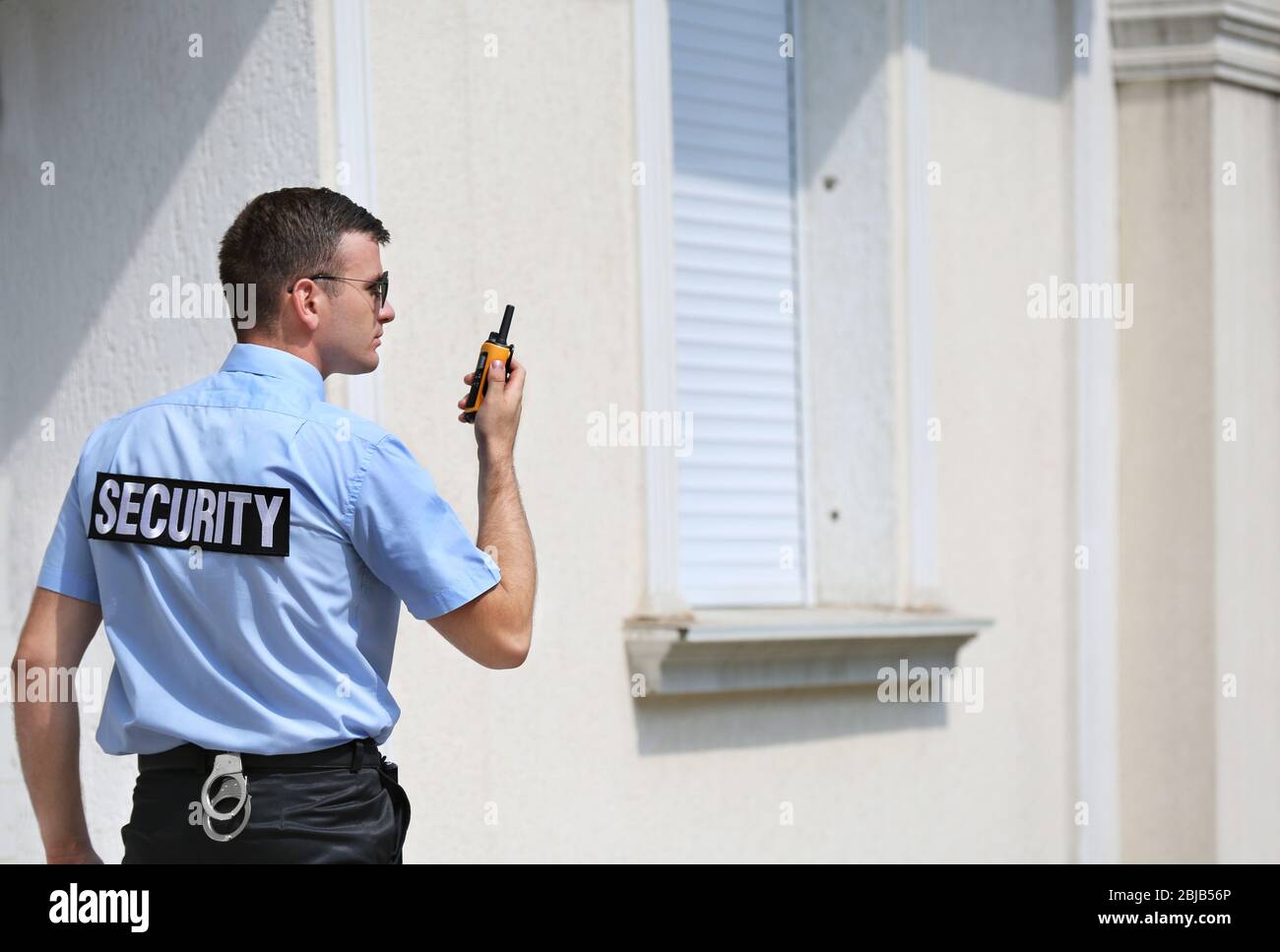 Male security guard with portable radio outdoors Stock Photo - Alamy