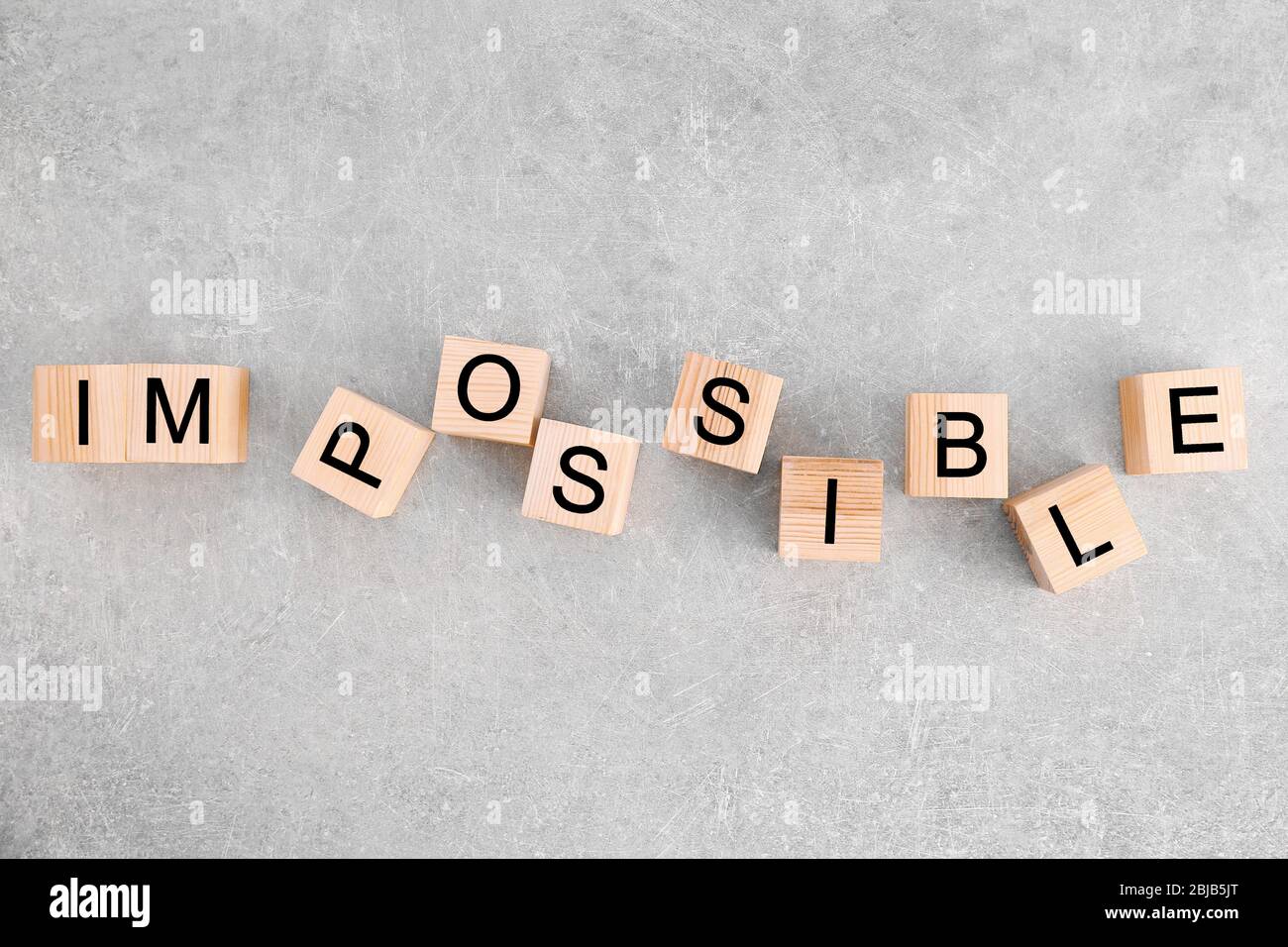 Wooden cubes with word IMPOSSIBLE on light background Stock Photo - Alamy