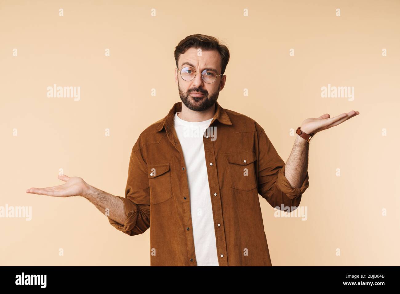Portrait of a confused young arttractive bearded man wearing casual ...
