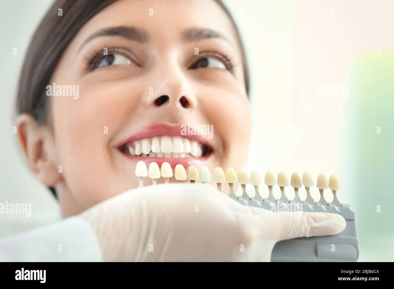 Dentist matching teeth colour in office Stock Photo - Alamy
