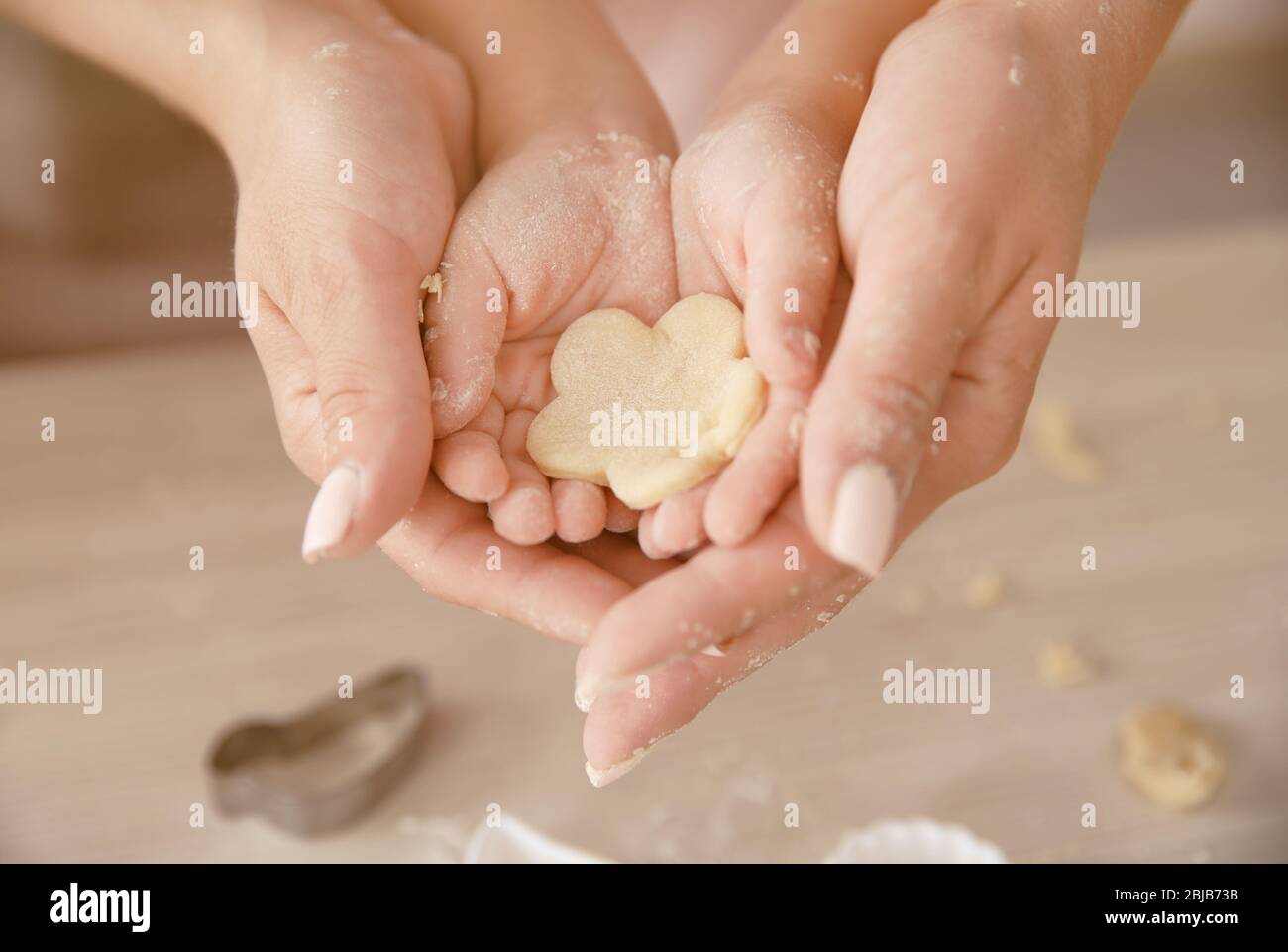Mother and kid holding uncooked biscuit, closeup Stock Photo - Alamy
