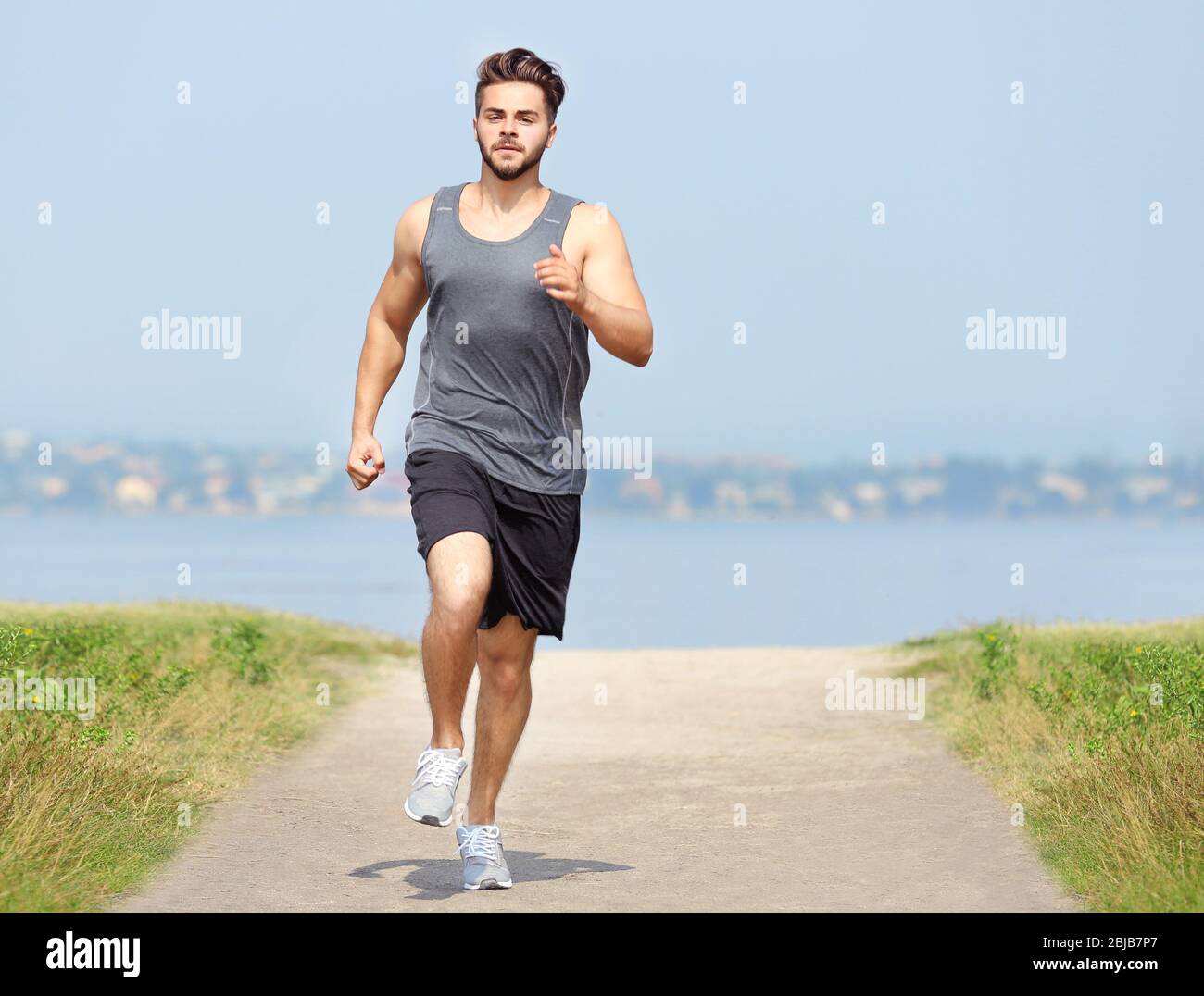 Man jogging on river background Stock Photo - Alamy