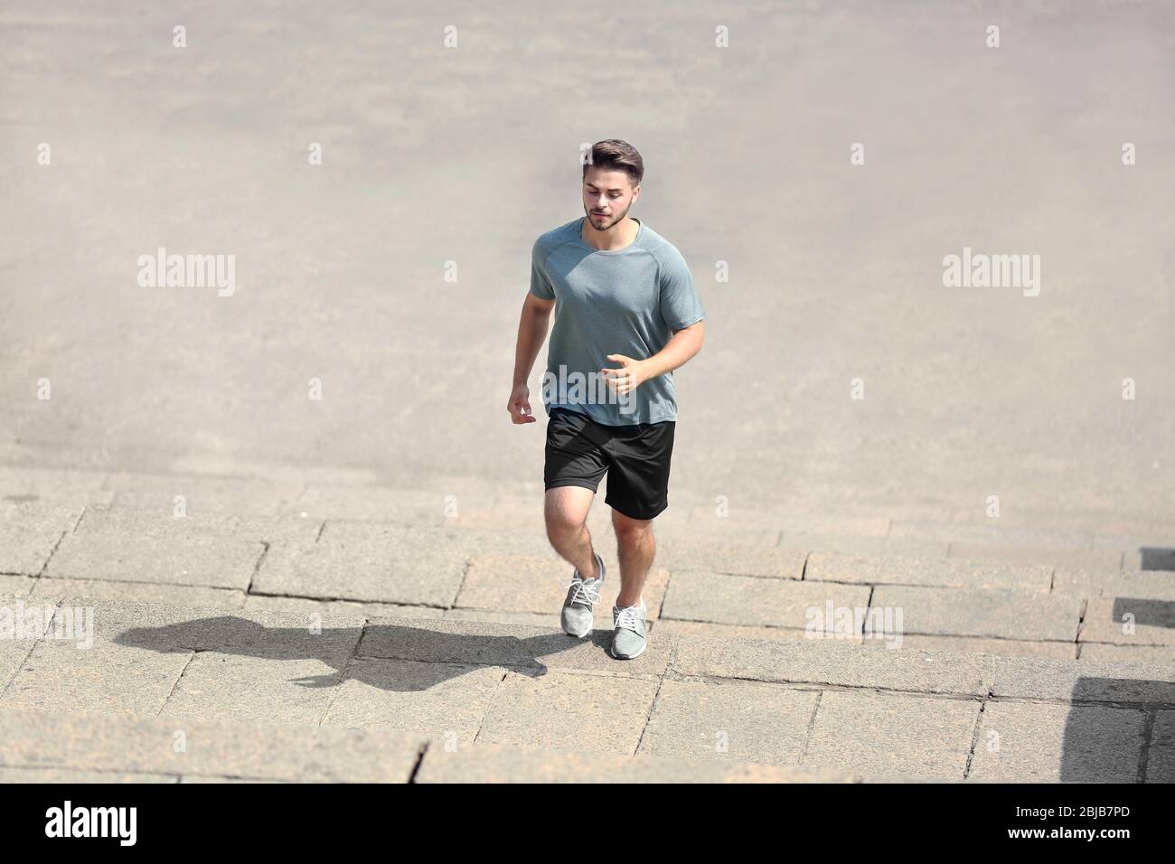 Young man running on stairs outdoors Stock Photo - Alamy