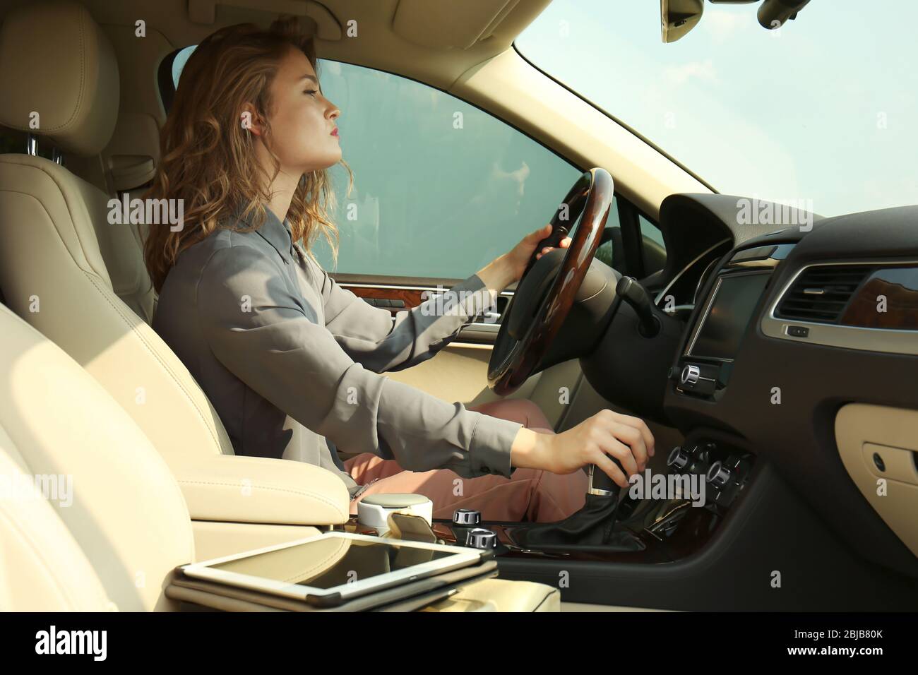 Pretty young woman driving car Stock Photo - Alamy