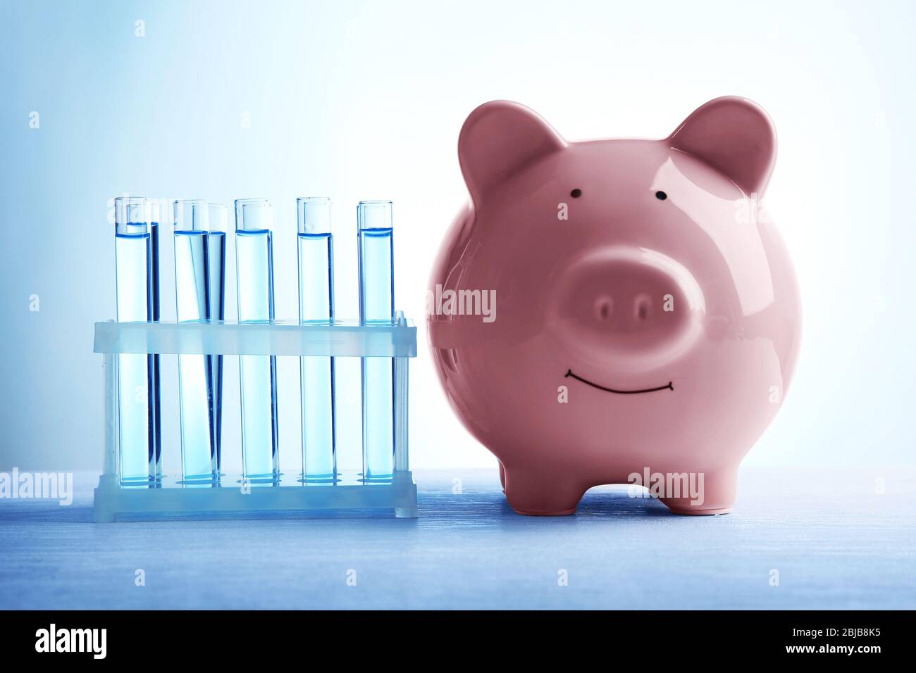 Pig money box and water in tubes on table. Saving water concept Stock ...