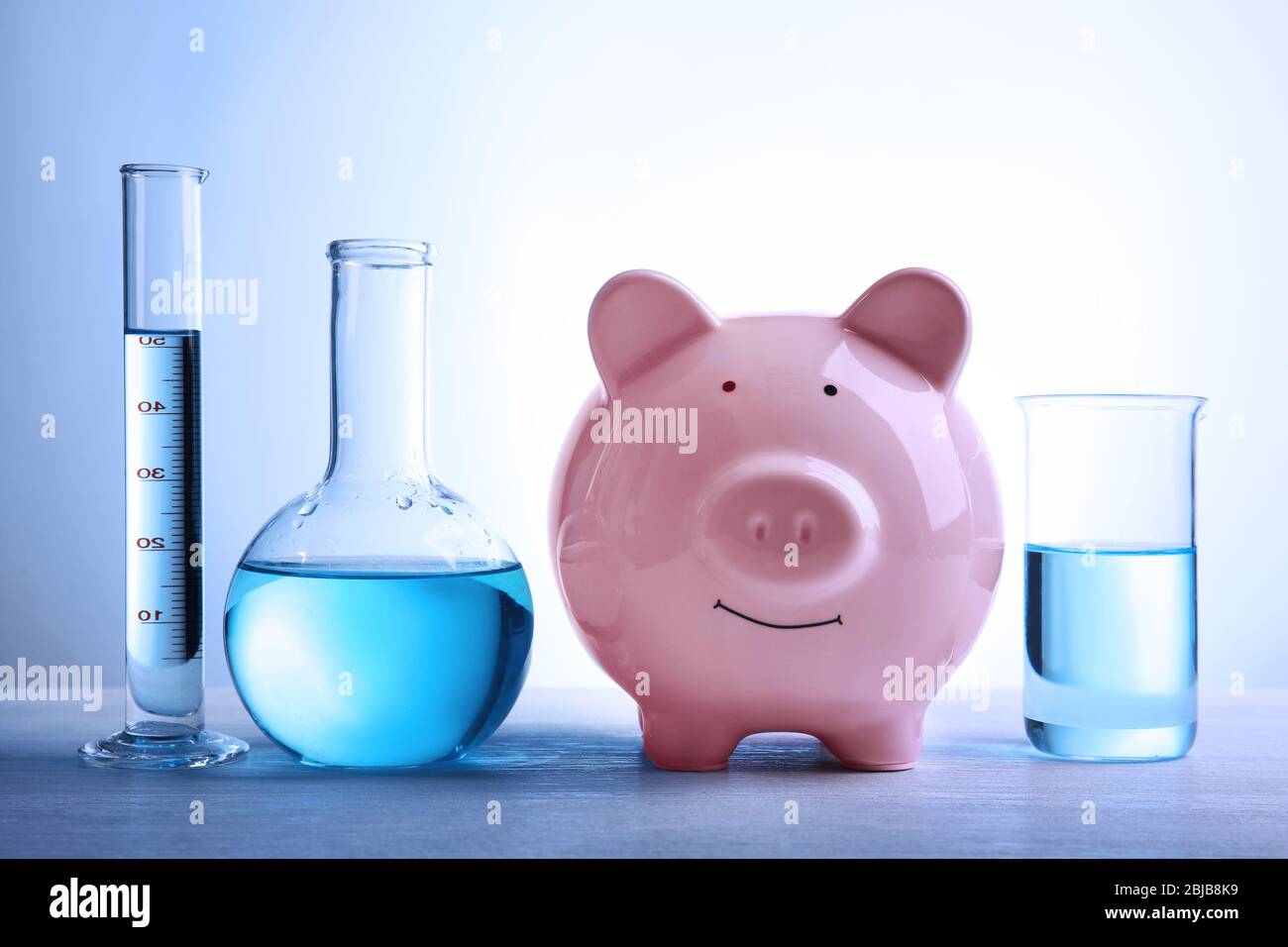 Pig money box and water in tubes on table. Saving water concept Stock ...