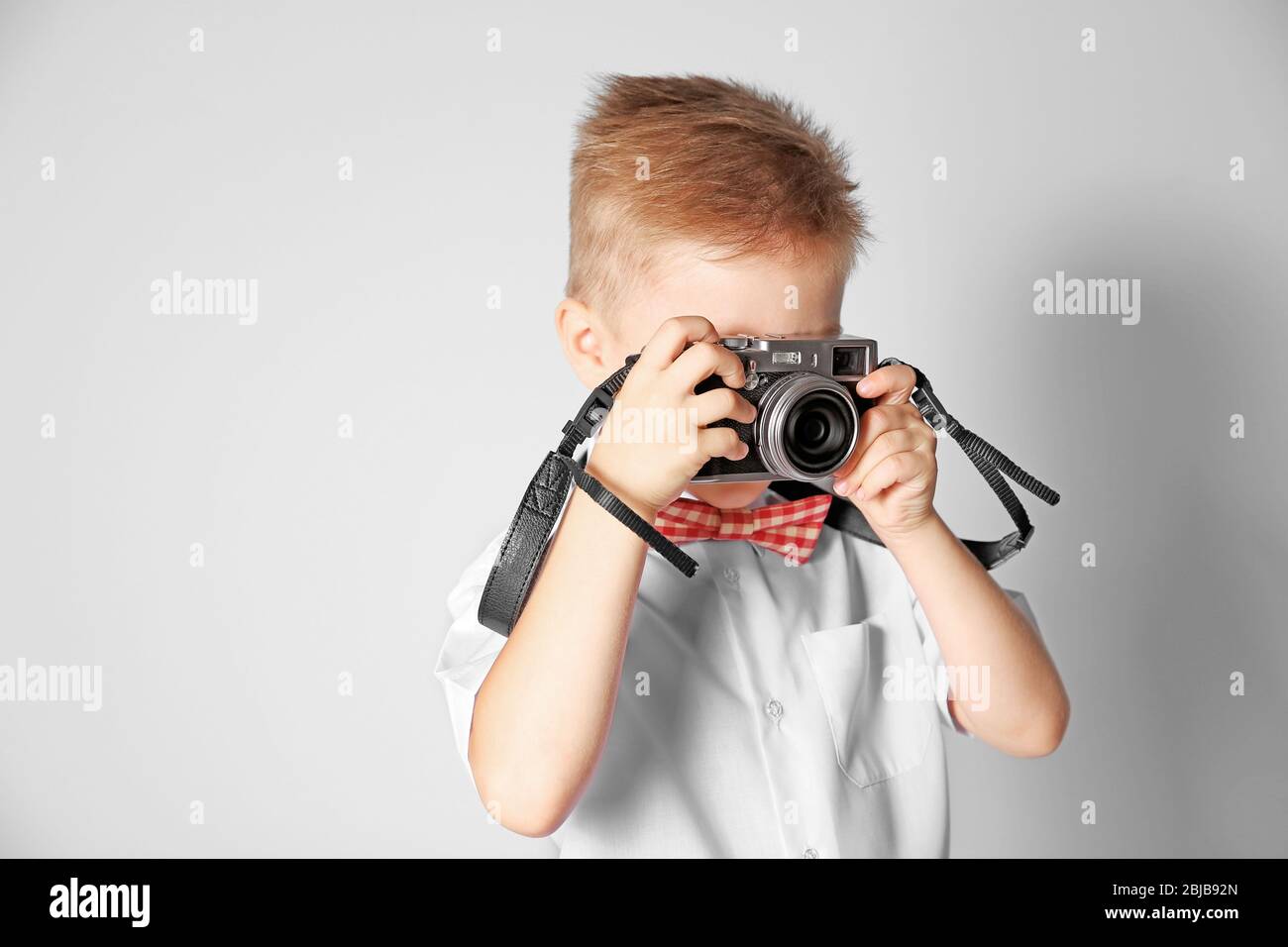 Little boy with vintage camera on grey background Stock Photo - Alamy