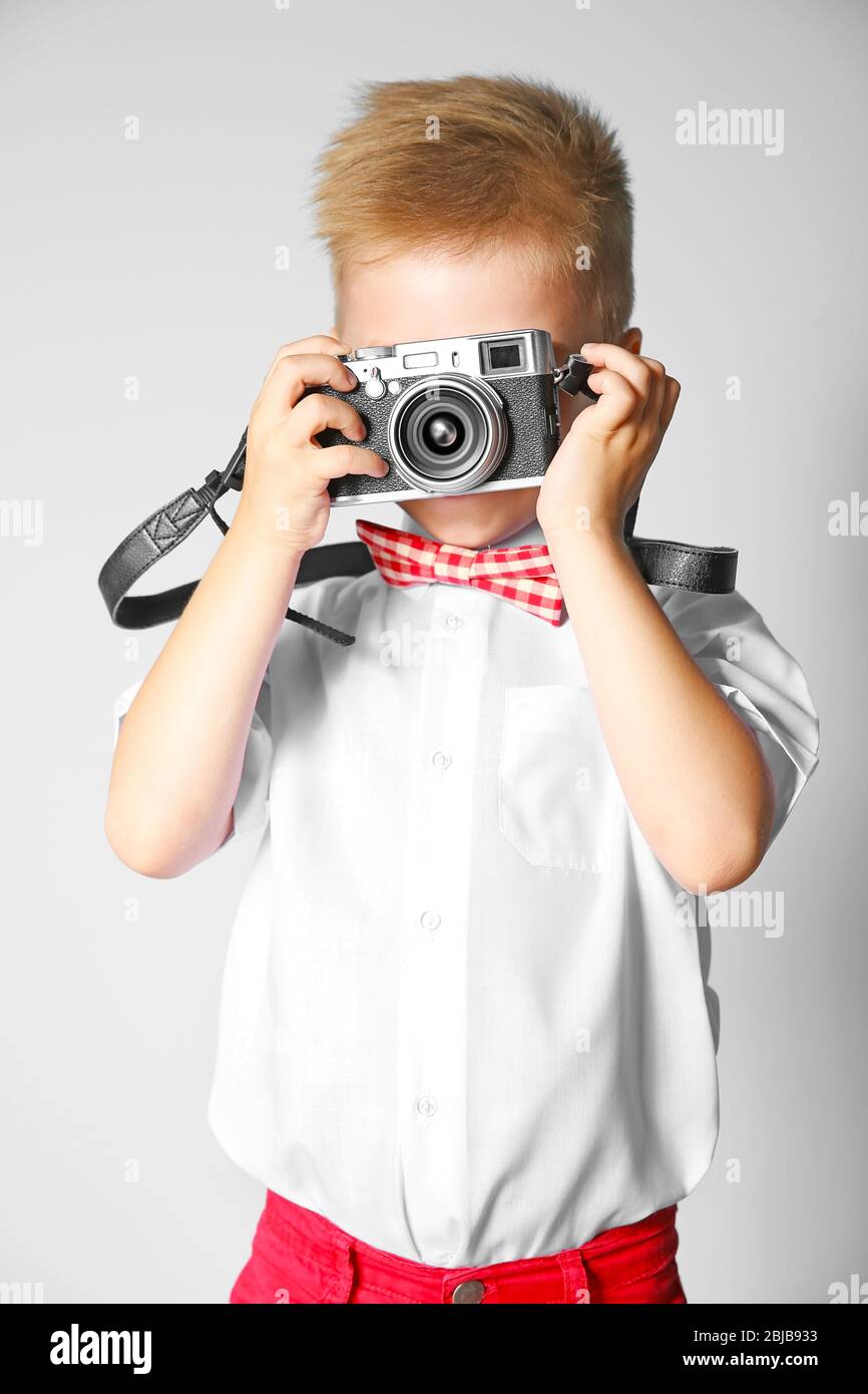 Little boy with vintage camera on grey background Stock Photo - Alamy