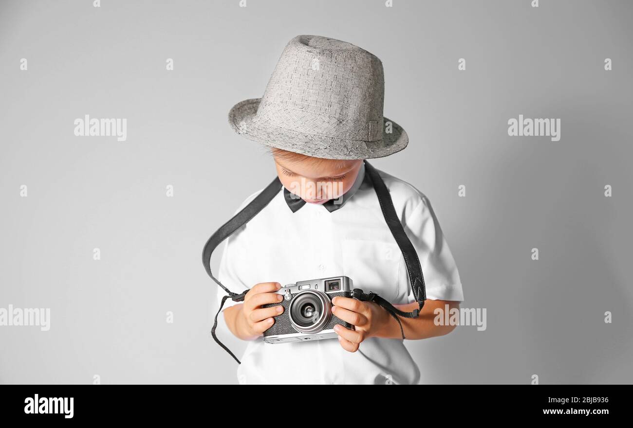 Little boy with vintage camera on grey background Stock Photo - Alamy