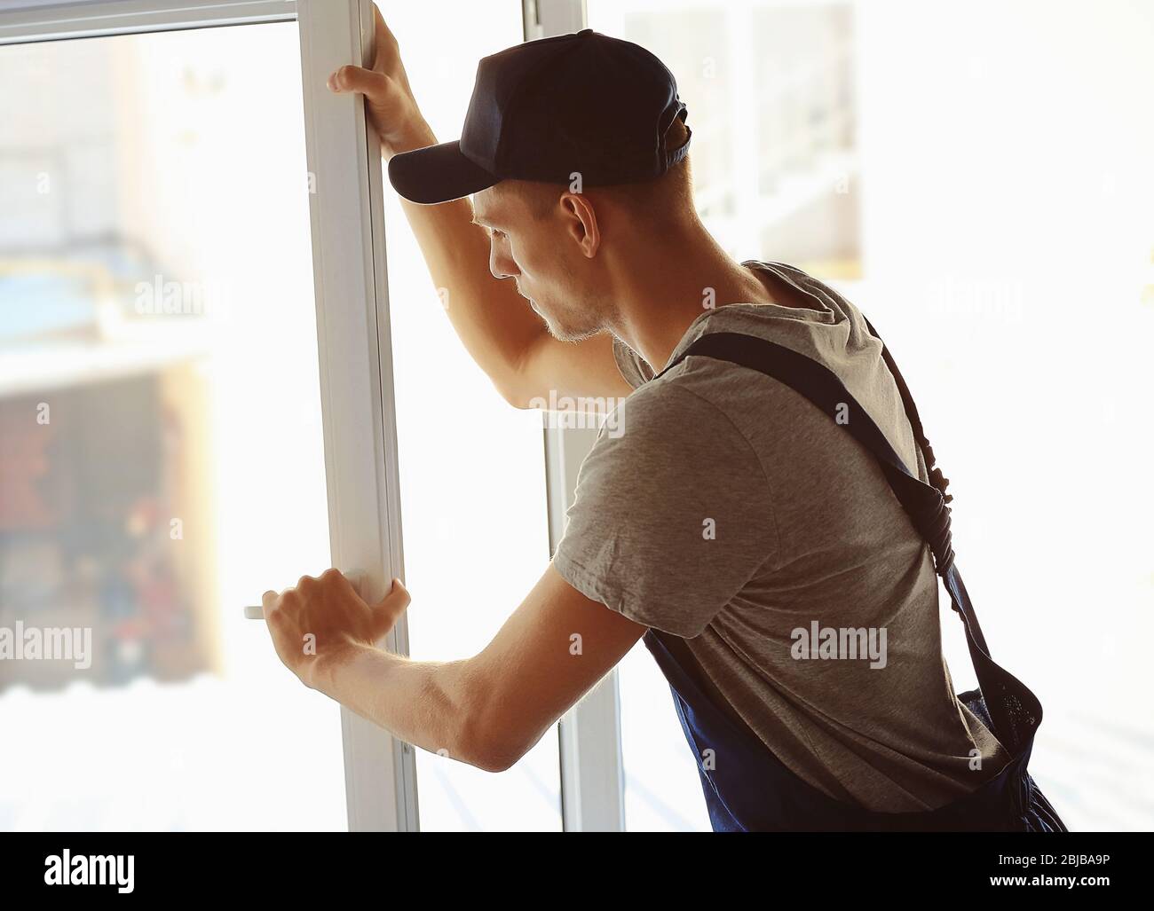 Construction worker installing window in house Stock Photo - Alamy