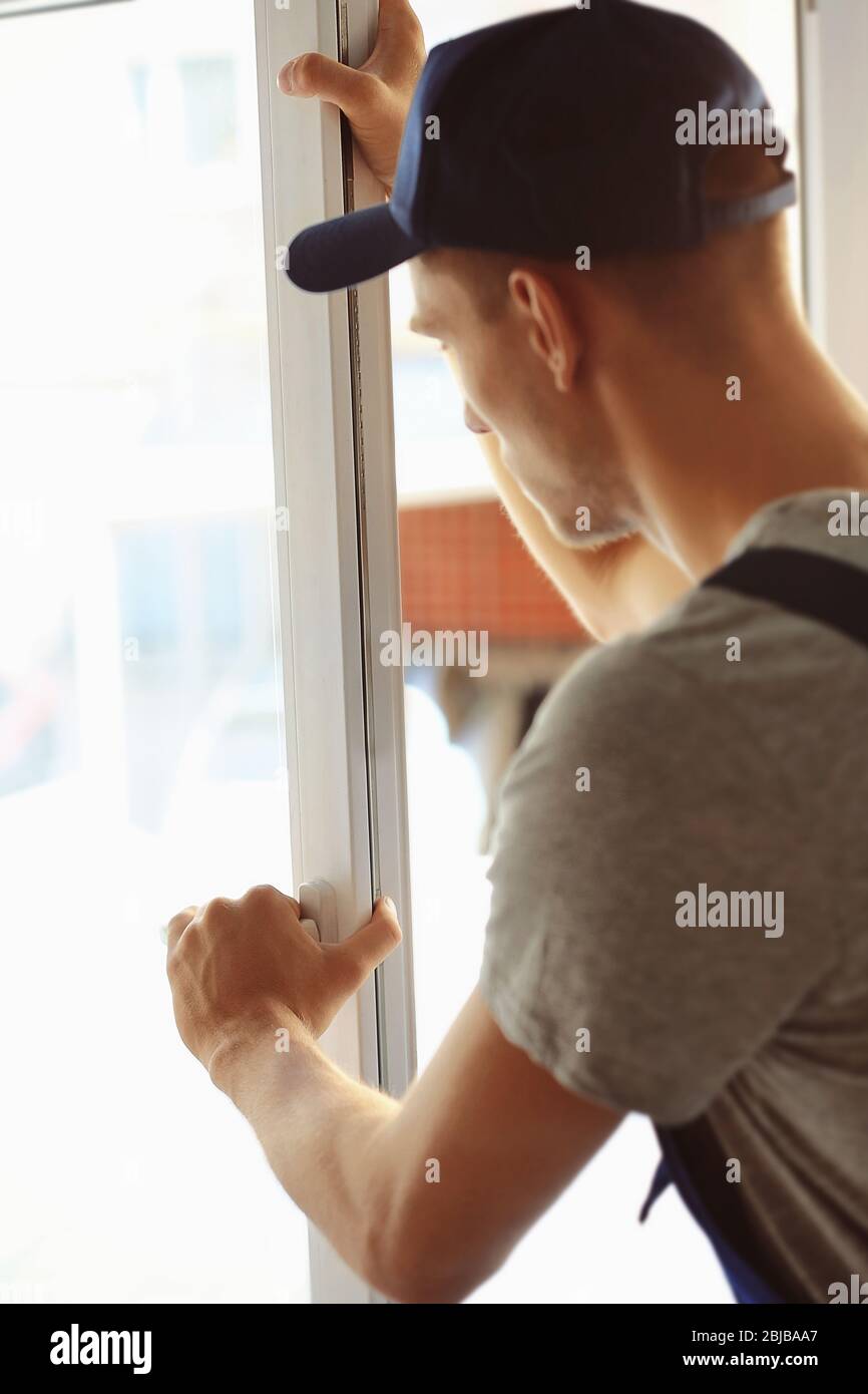 Construction worker installing window in house Stock Photo - Alamy