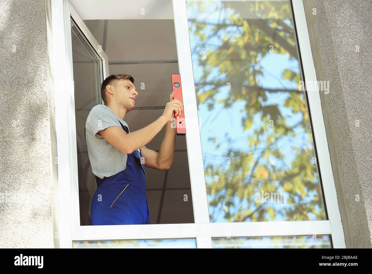 Construction worker installing window in house Stock Photo - Alamy
