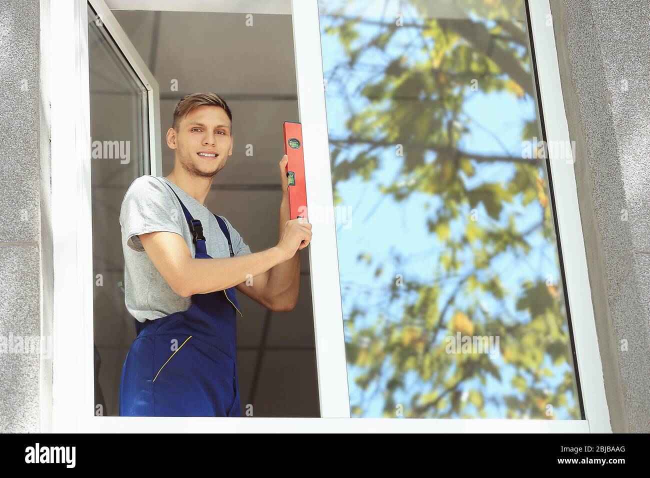 Construction worker installing window in house Stock Photo - Alamy