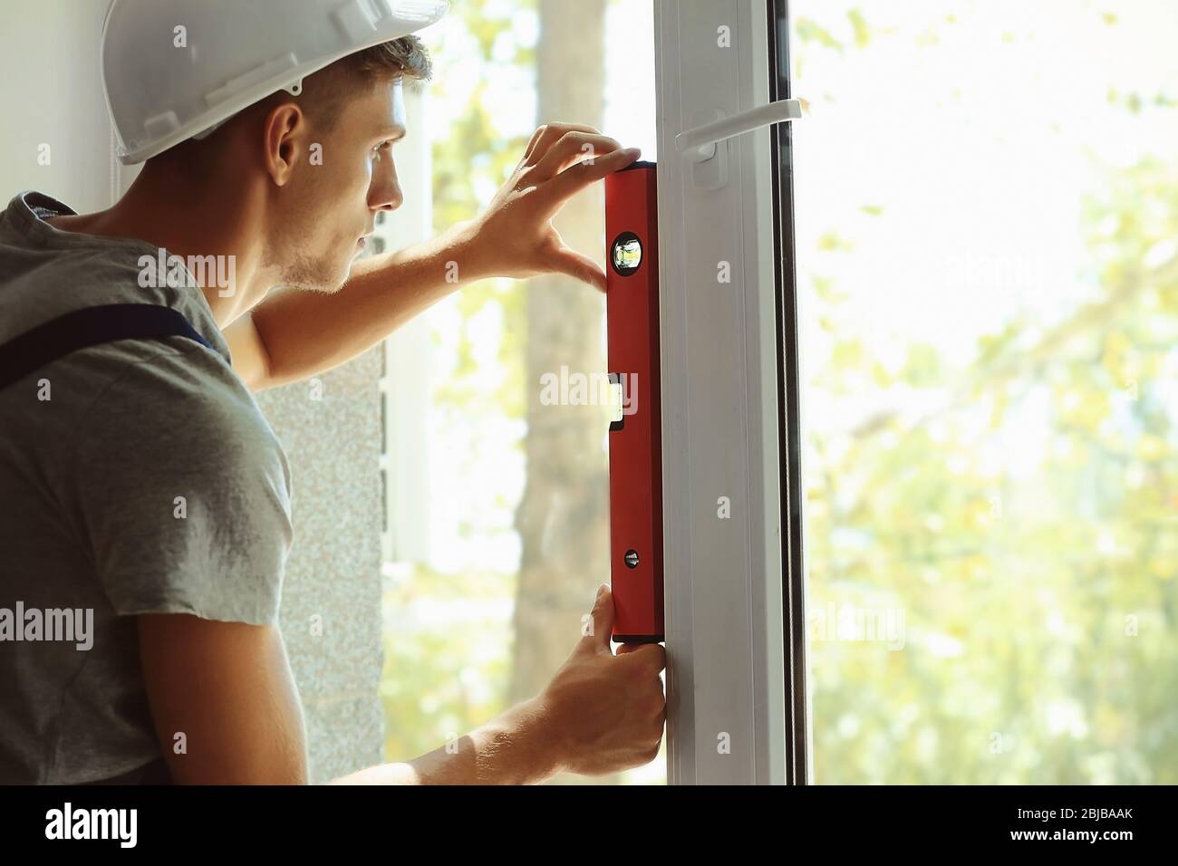 Construction worker installing window in house Stock Photo - Alamy