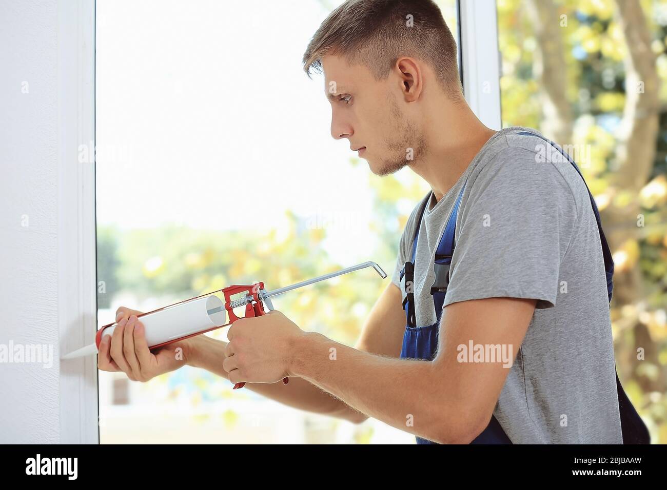Construction worker installing window in house Stock Photo - Alamy