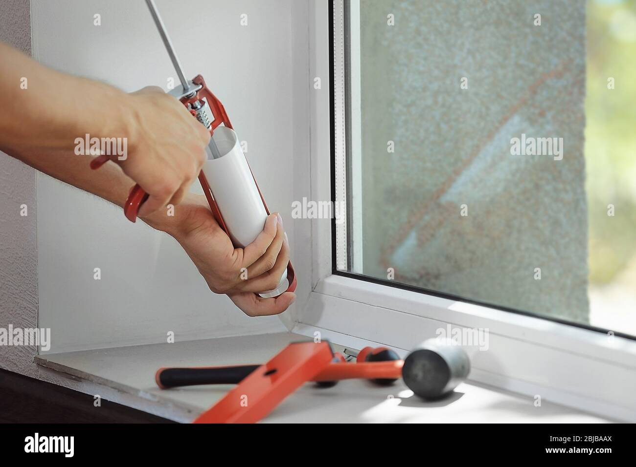 Construction worker installing window in house Stock Photo - Alamy