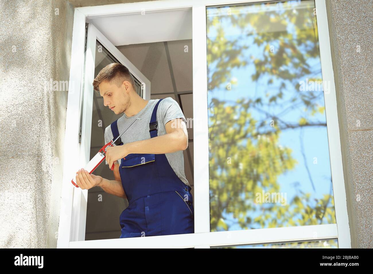 Construction worker installing window in house Stock Photo - Alamy