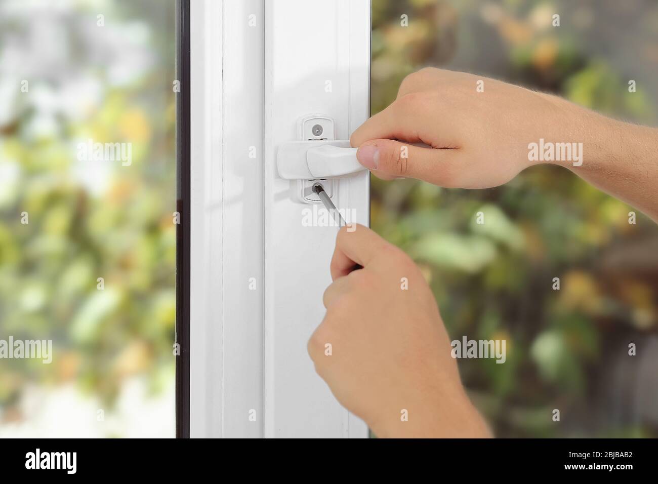 Construction worker repairing window handle Stock Photo - Alamy