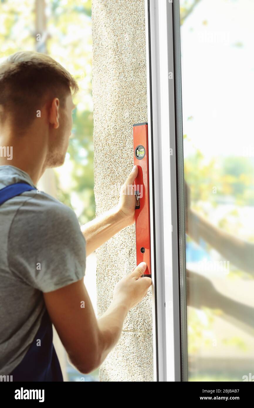 Construction worker installing window in house Stock Photo - Alamy