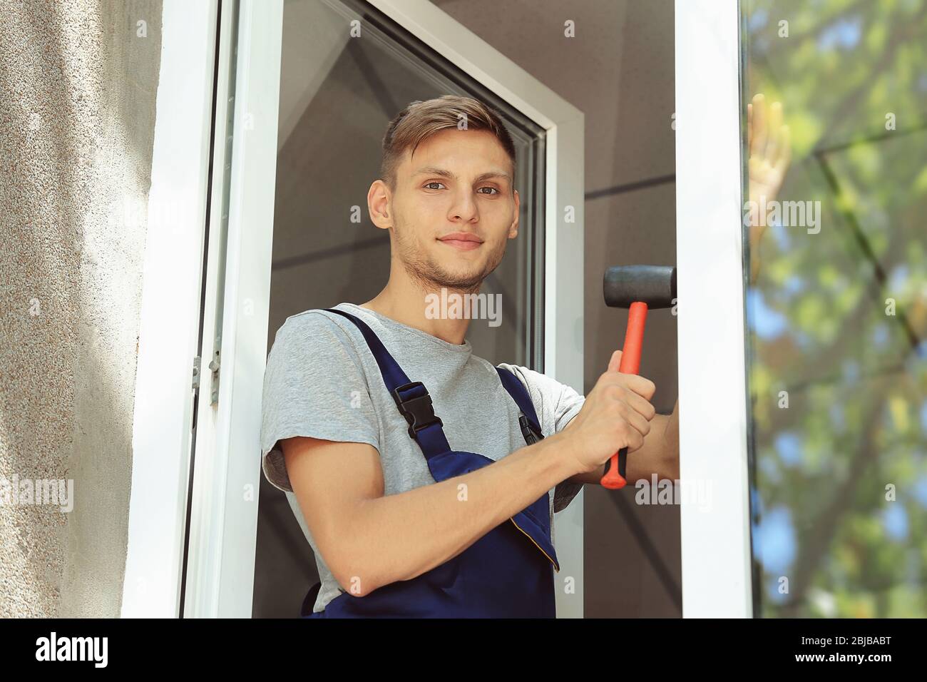 Construction worker installing window in house Stock Photo - Alamy