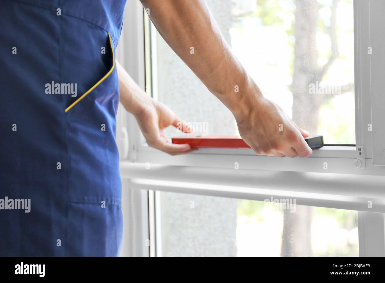 Construction worker installing window in house Stock Photo - Alamy