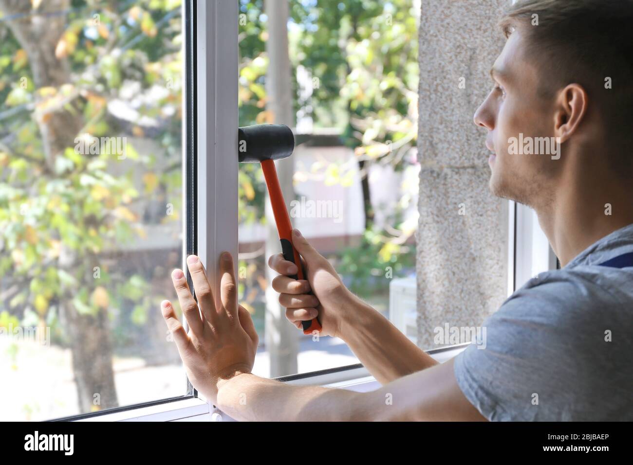 Construction worker installing window in house Stock Photo - Alamy