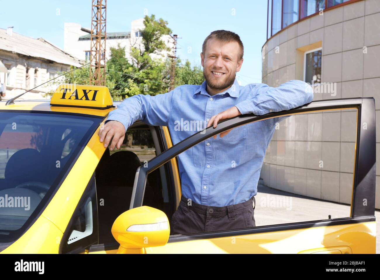 Handsome taxi driver near car on station Stock Photo - Alamy