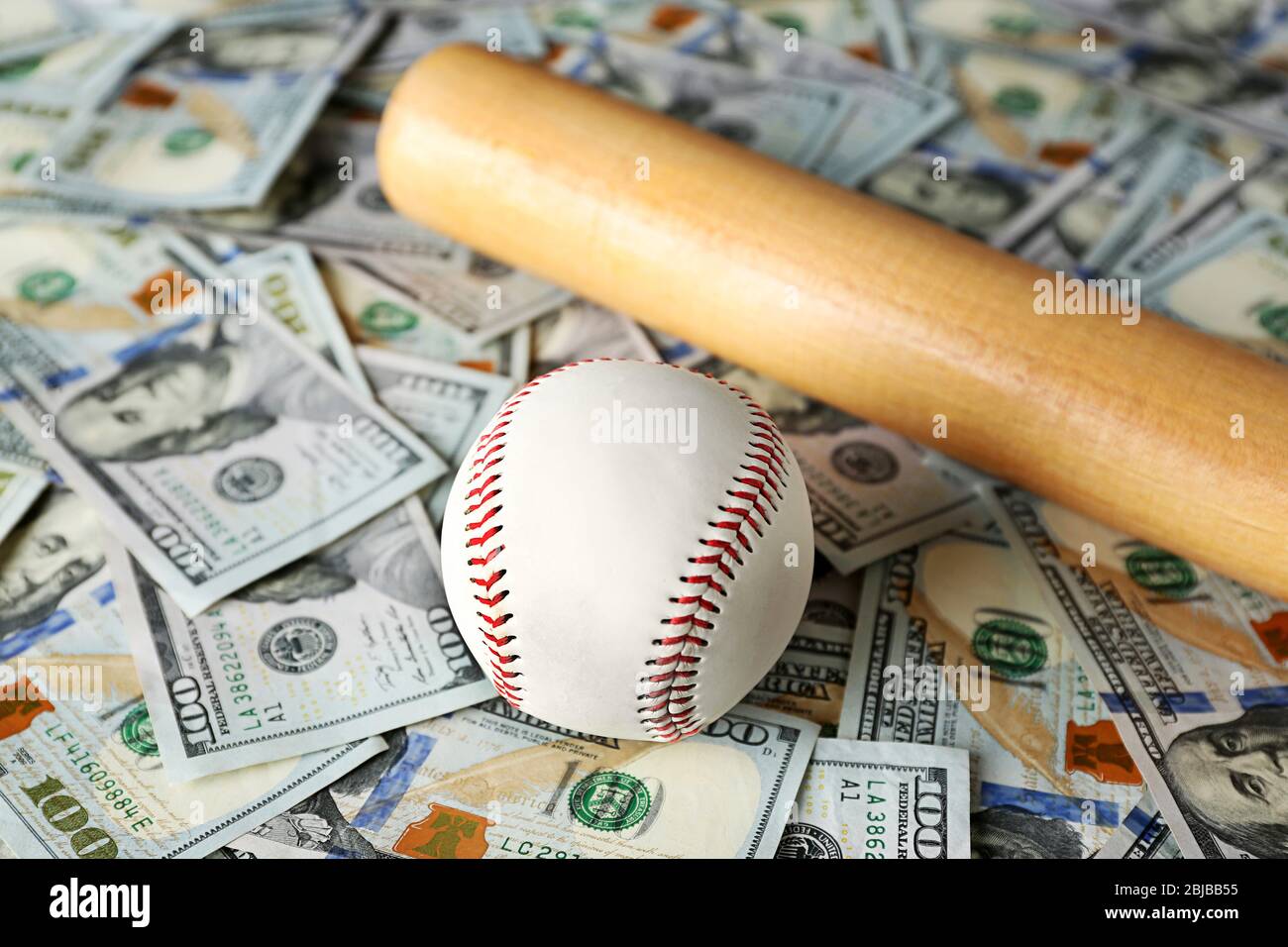 Baseball-bat and ball on dollars Stock Photo - Alamy