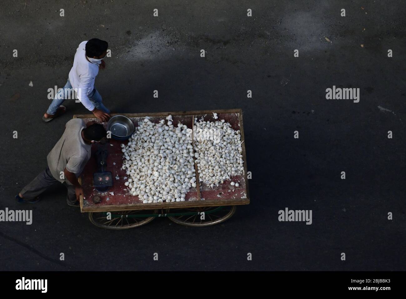 Two men with cart and garlic Stock Photo - Alamy