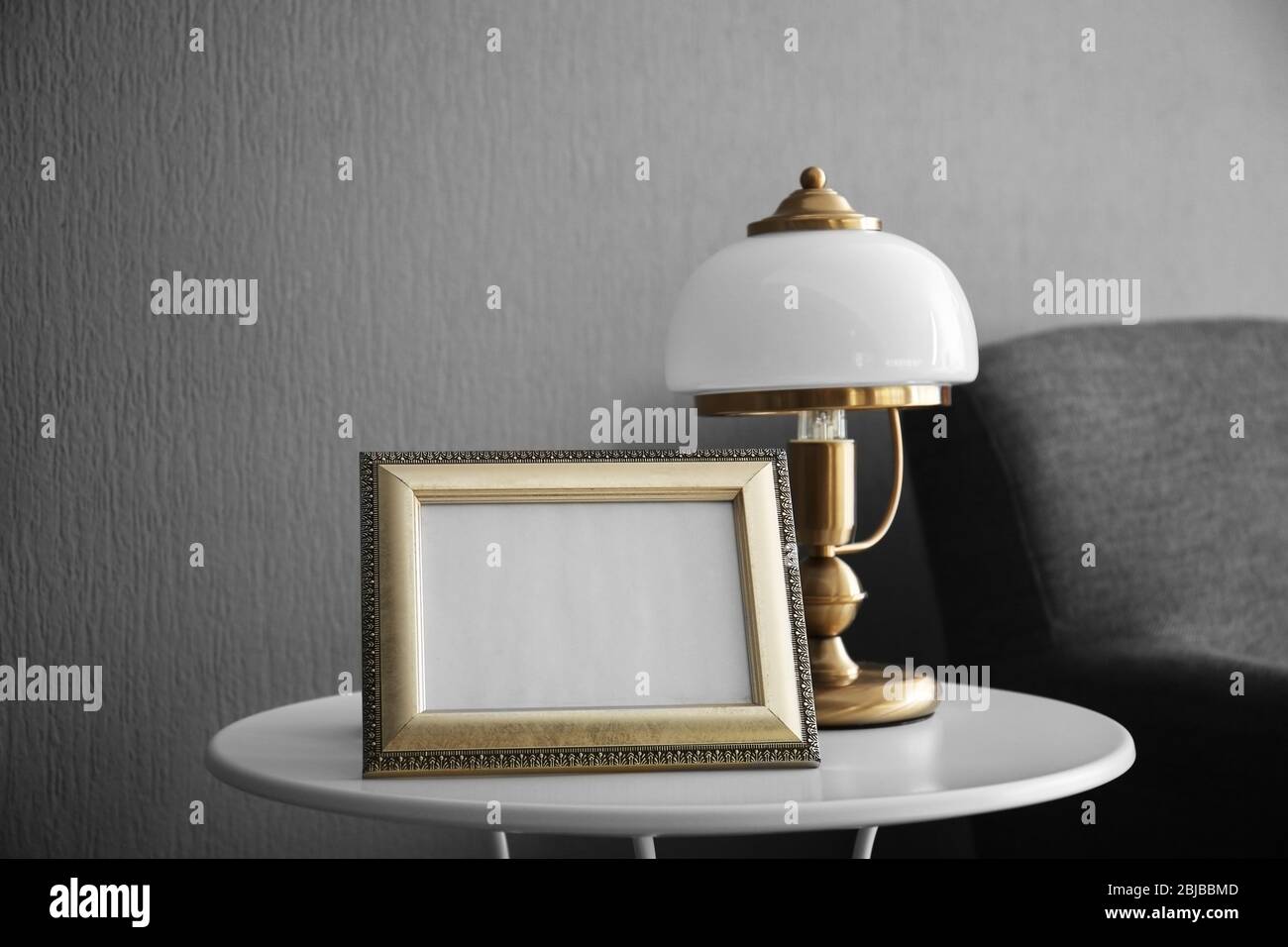Photo frame and standing lamp on white table Stock Photo - Alamy