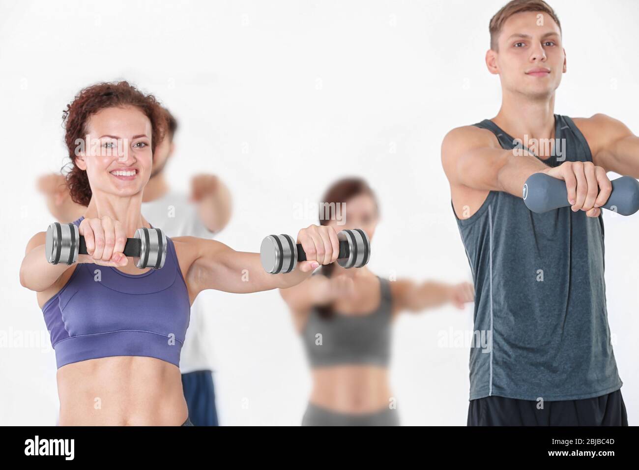 Group of people doing exercises with dumbbells in gym Stock Photo - Alamy