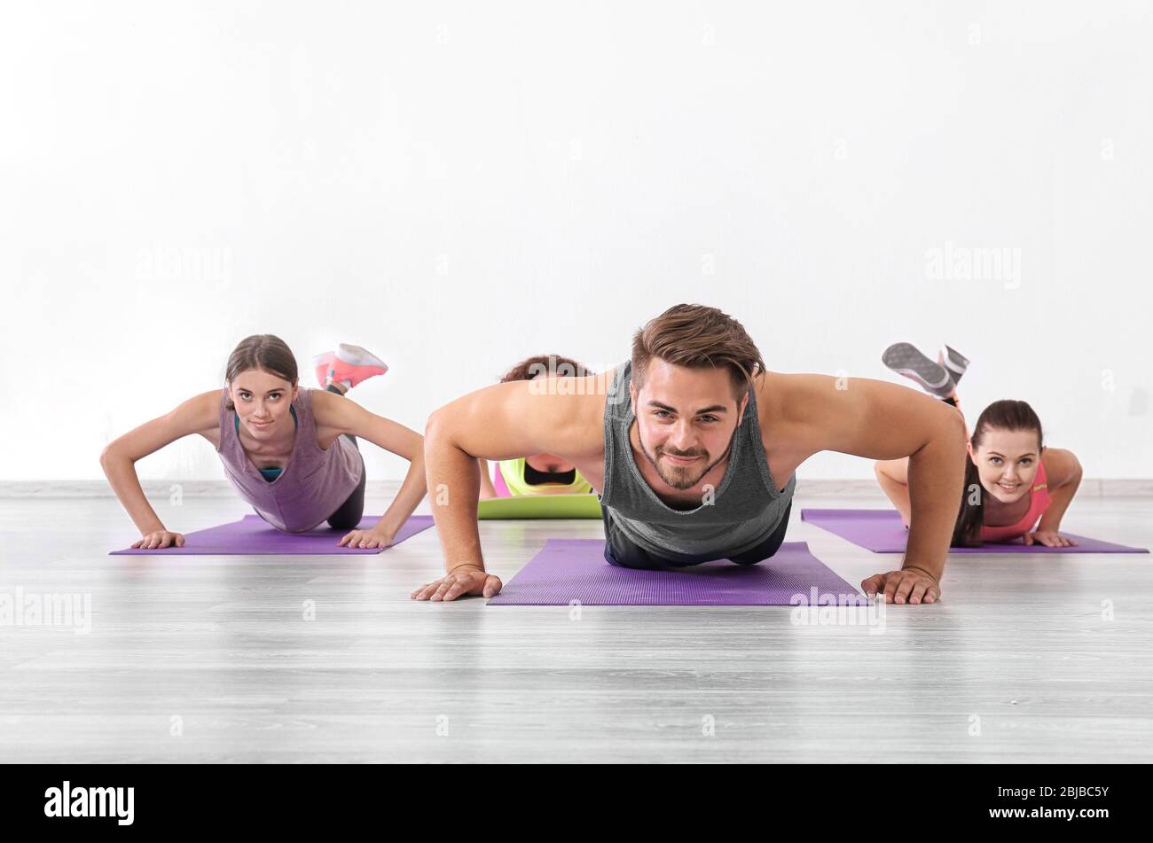 Group of people doing push-ups in yoga class Stock Photo - Alamy
