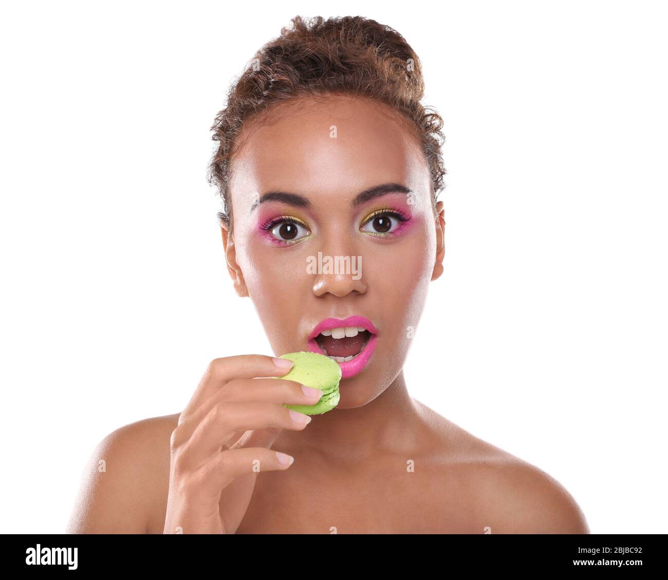 Young woman eating delicious macaroon on white background Stock Photo ...