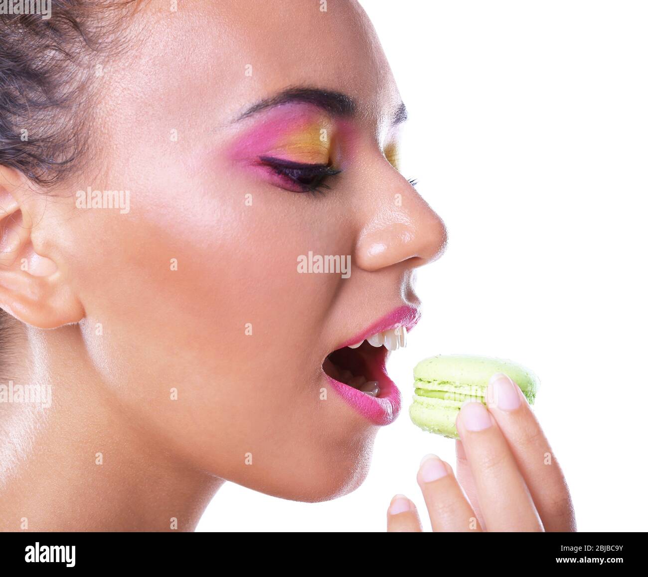 Young woman eating delicious macaroon on white background Stock Photo ...