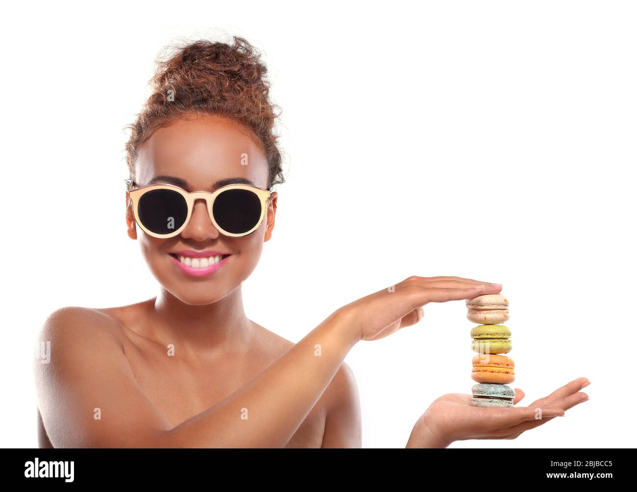 Young woman holding pile of macaroons on white background Stock Photo ...