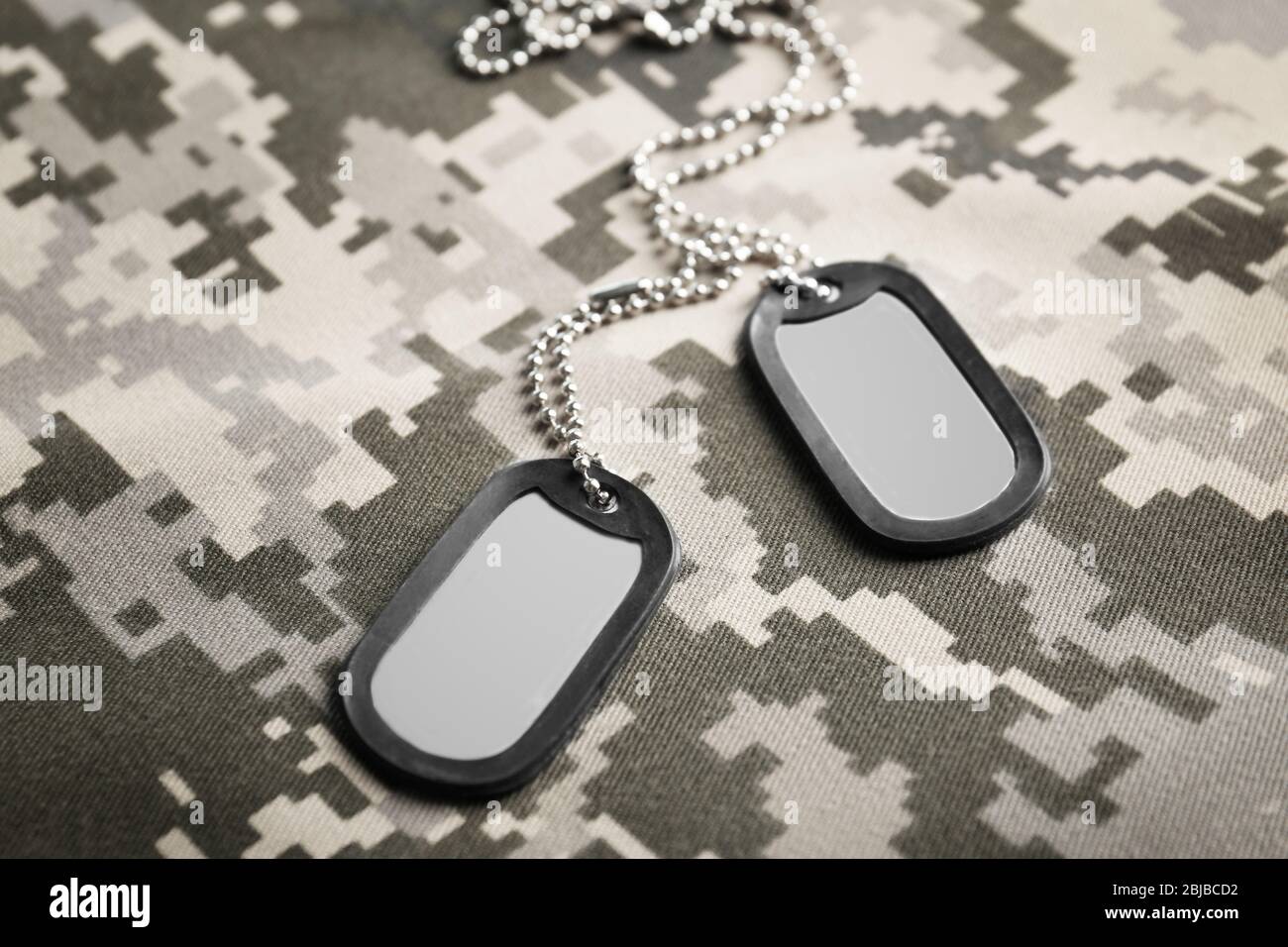Army tokens on military uniform background Stock Photo - Alamy