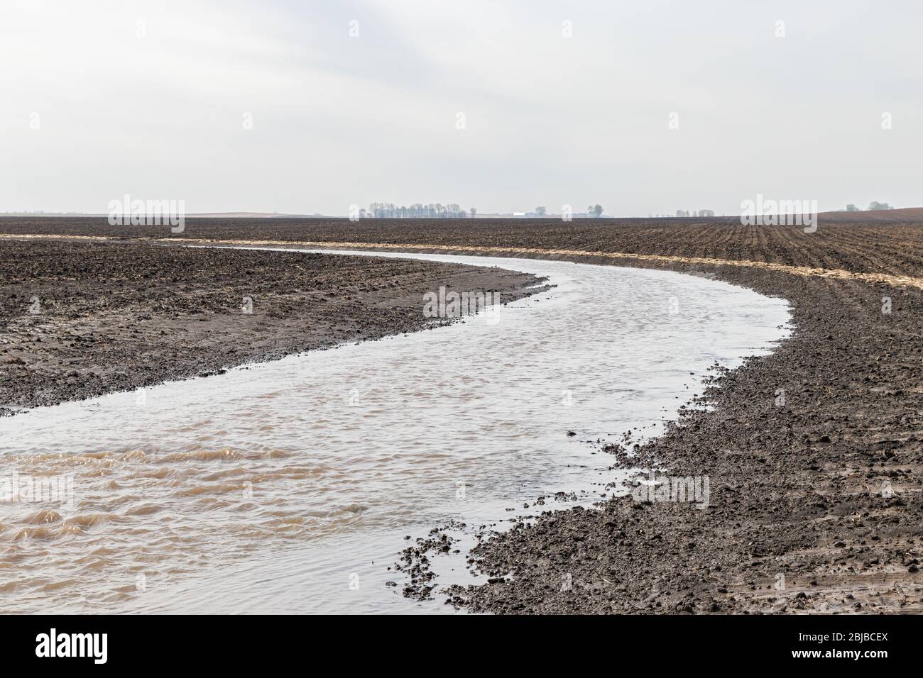 water flowing in farm field after heavy spring rains and storms brought ...